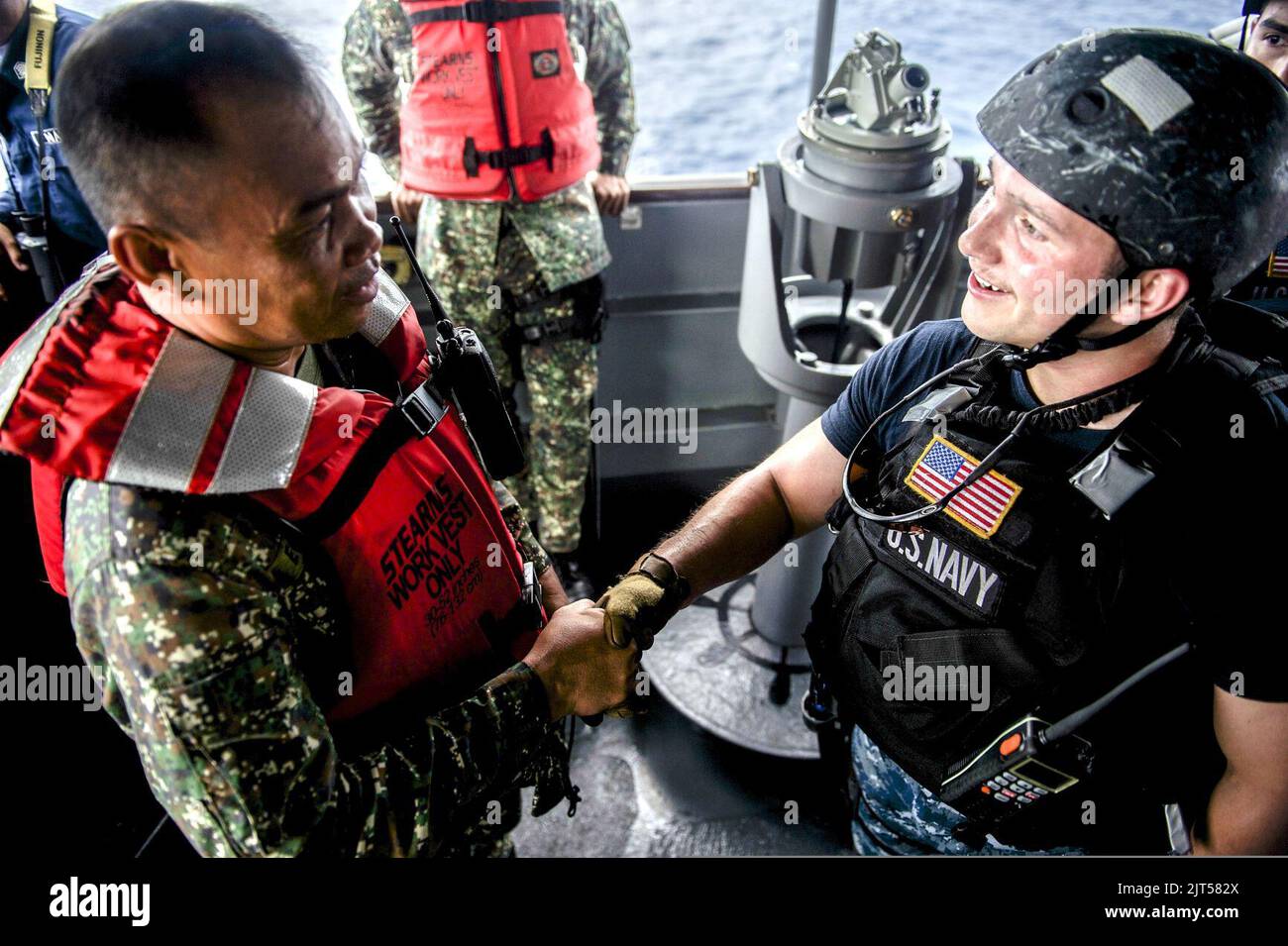 U.S. Navy Lt. j.g. right, assigned to the guided missile destroyer USS ...