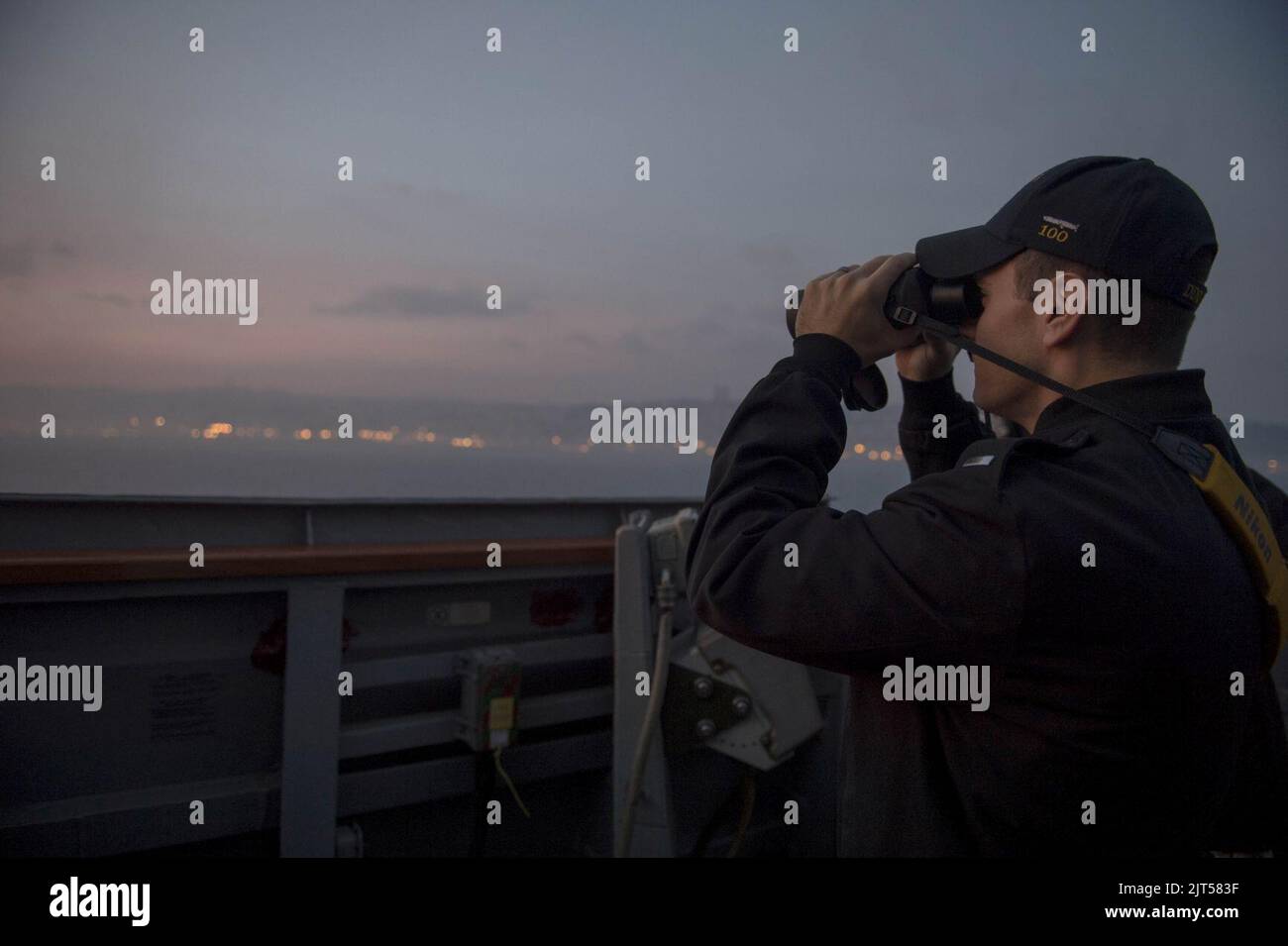U.S. Navy Lt. j.g. looks out binoculars for surface contacts on the ...