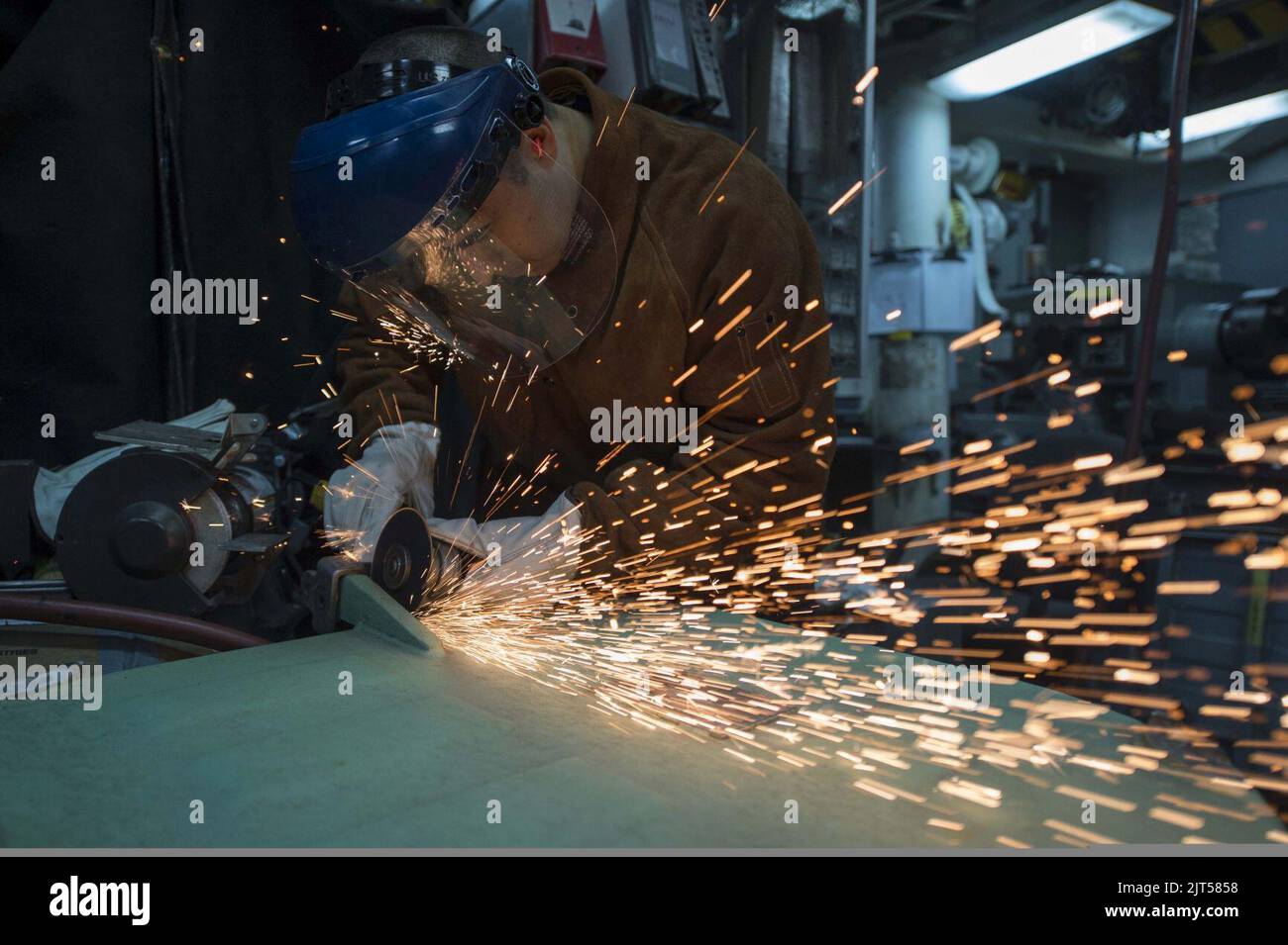 U.S. Navy Machinery Repairman Fireman Apprentice removes a hinge from a ...