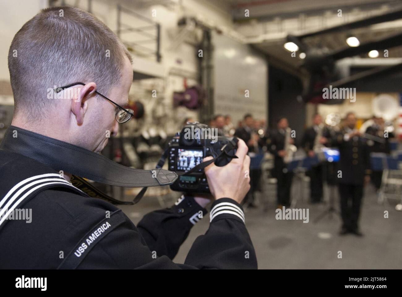 U.S. Navy Mass Communication Specialist 1st Class records video of a ...