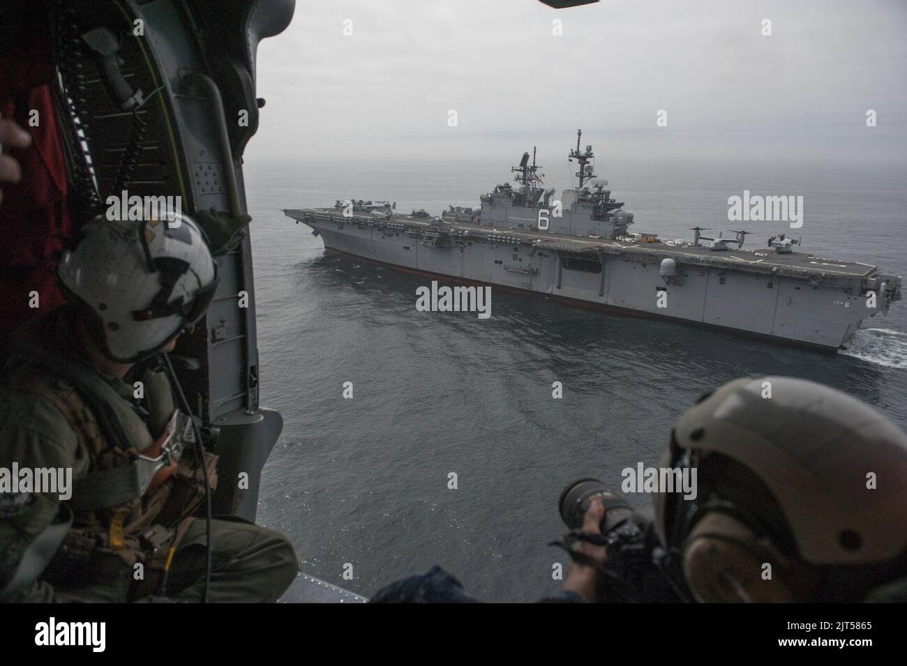 U.S. Navy Mass Communication Specialist 2nd Class takes photos of the ...