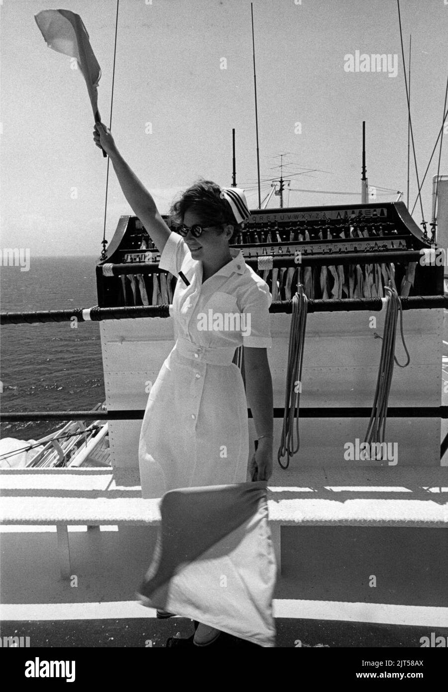 U.S. Navy nurse using flag semaphore signalling aboard USS Repose (AH ...