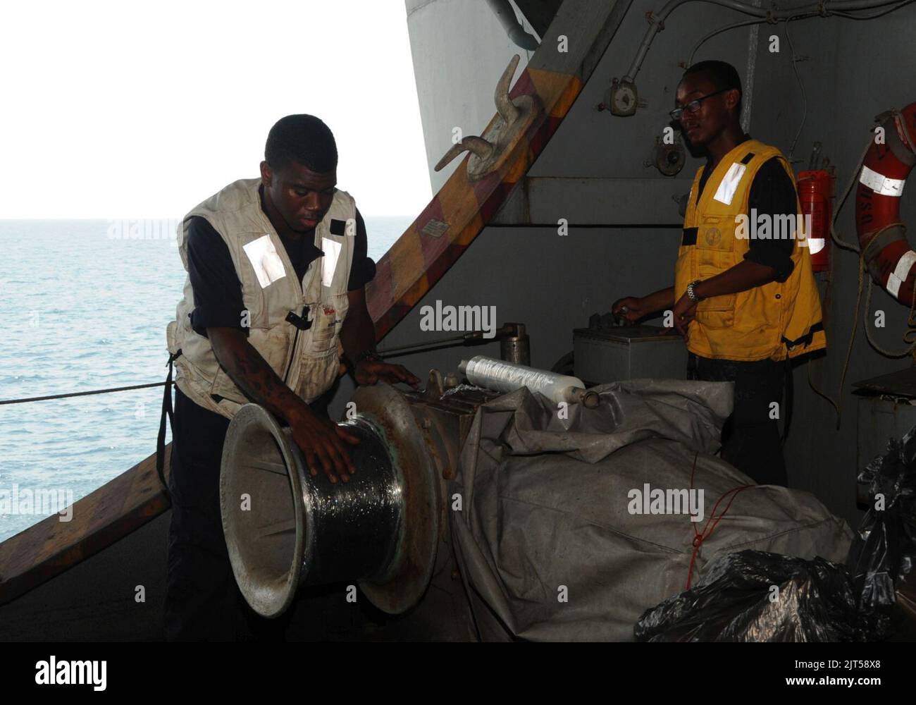 U.S. Navy Seaman left, and Seaman prepare a capstan for an underway ...