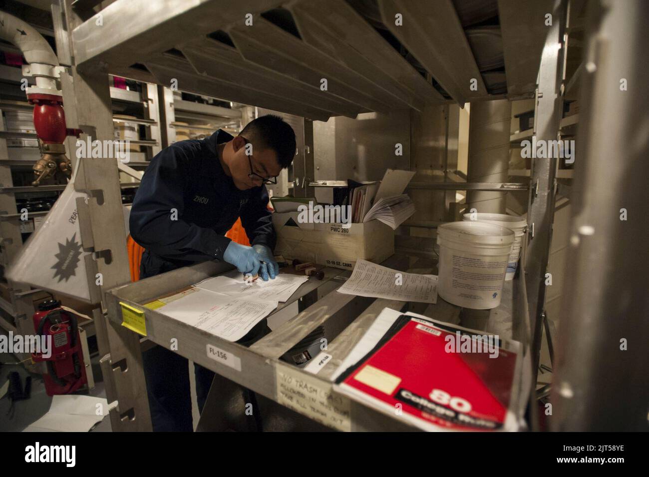 U.S. Navy Seaman organizes hazardous materials receipts aboard the ...