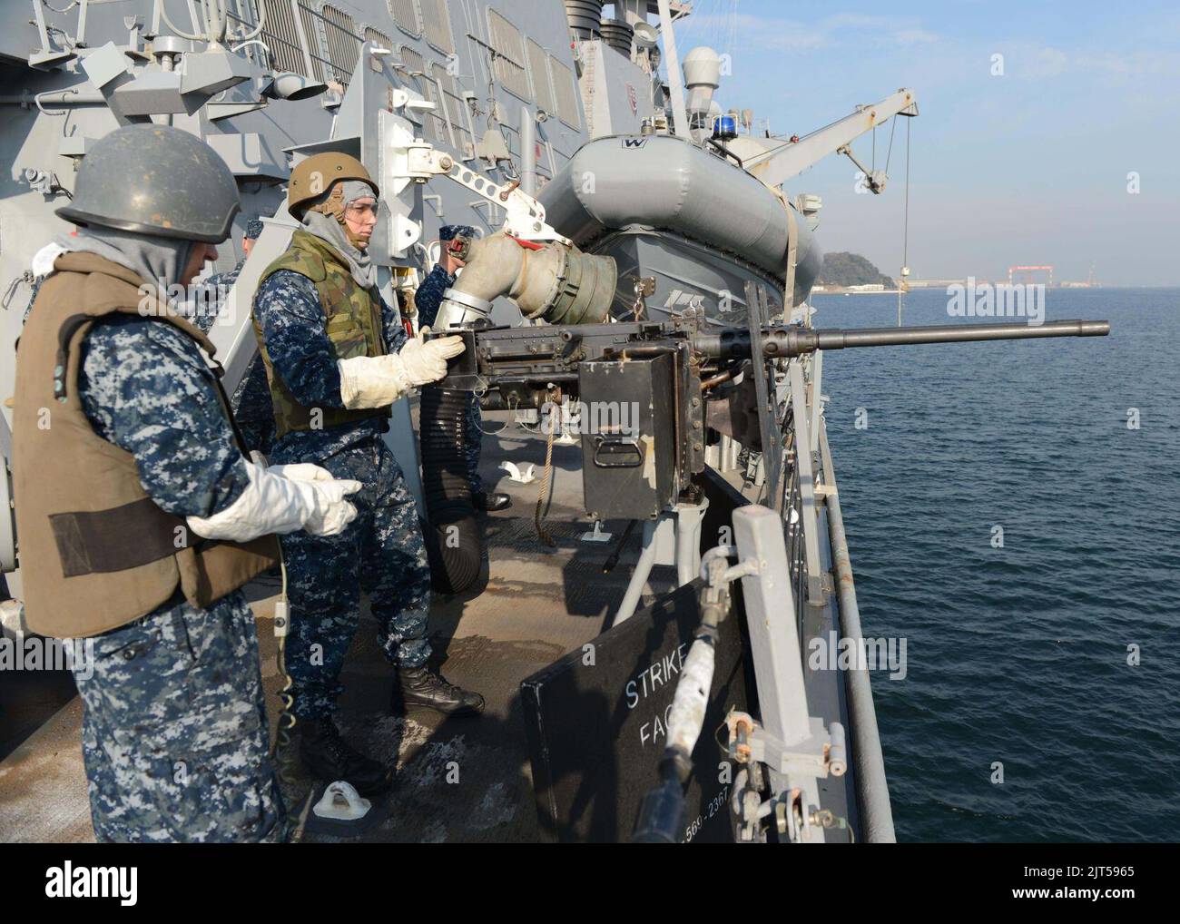 U.S. Navy Sonar Technician (Surface) 2nd Class right, mans a .50 ...