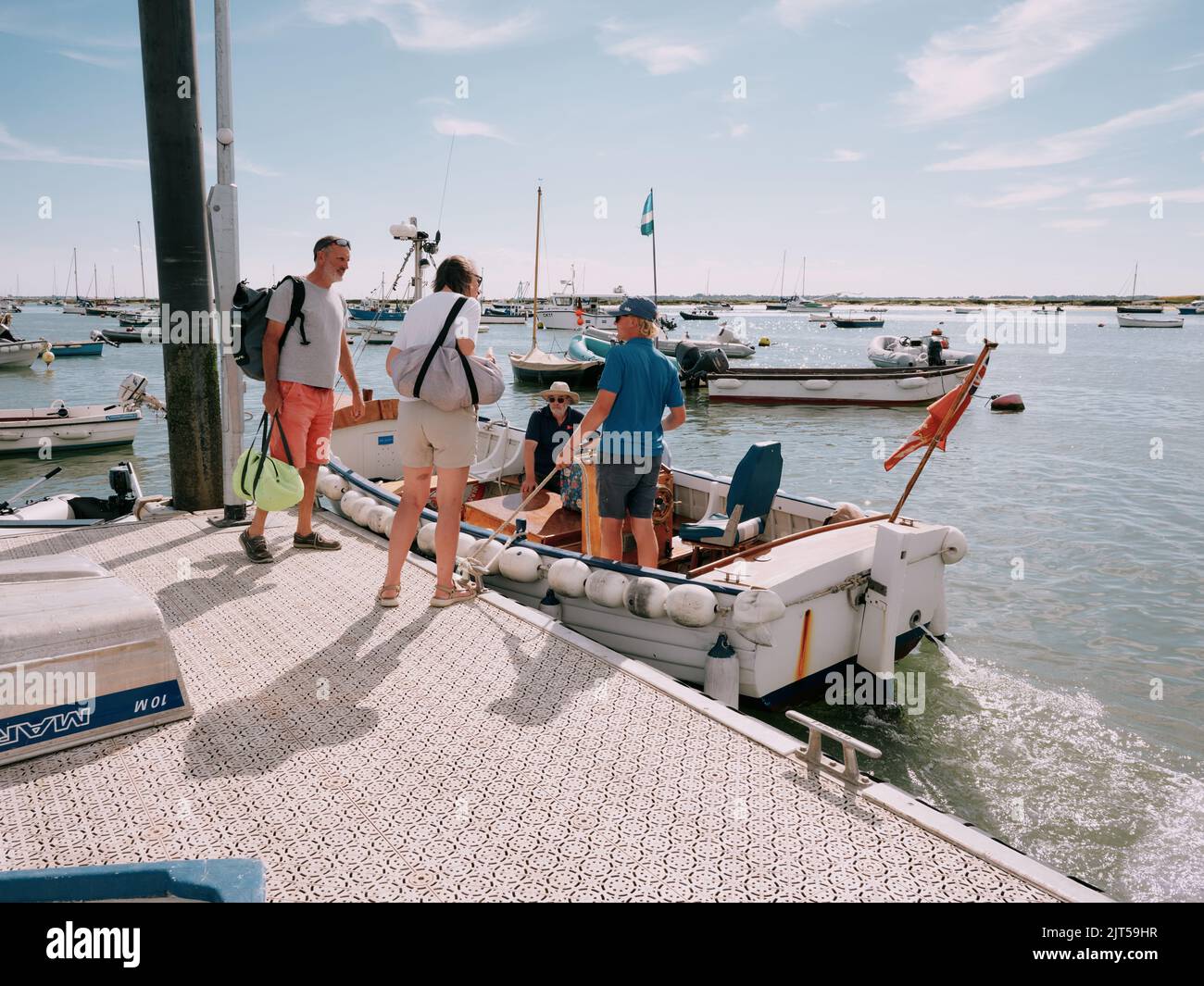 Summer visitors and the small passenger ferry on the floating pontoon ...