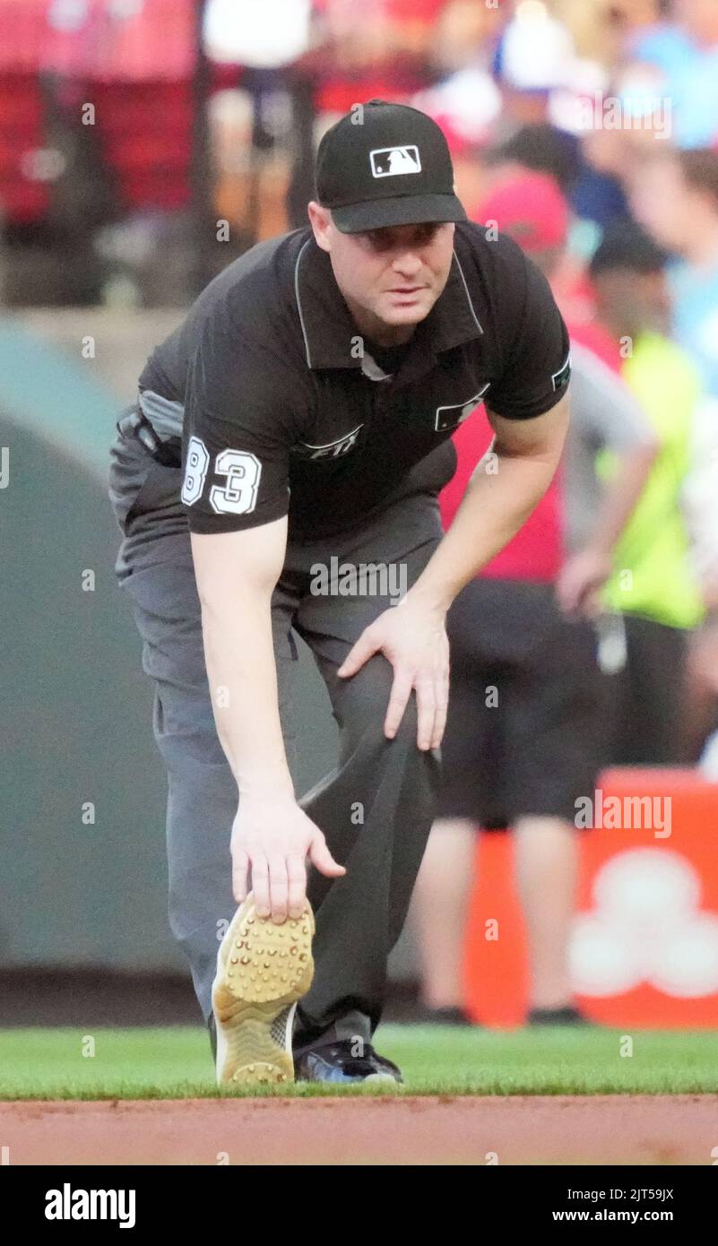 First base umpire Mike Estabrook stretches his foot between innings of ...