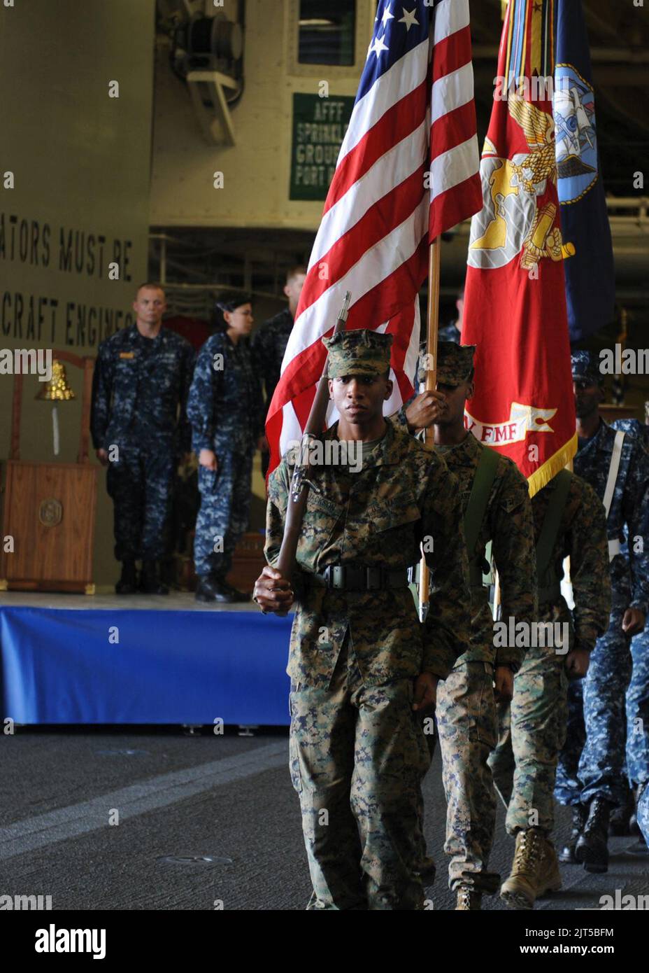 U.S. Sailors and Marines assigned to the color guard parade the colors ...