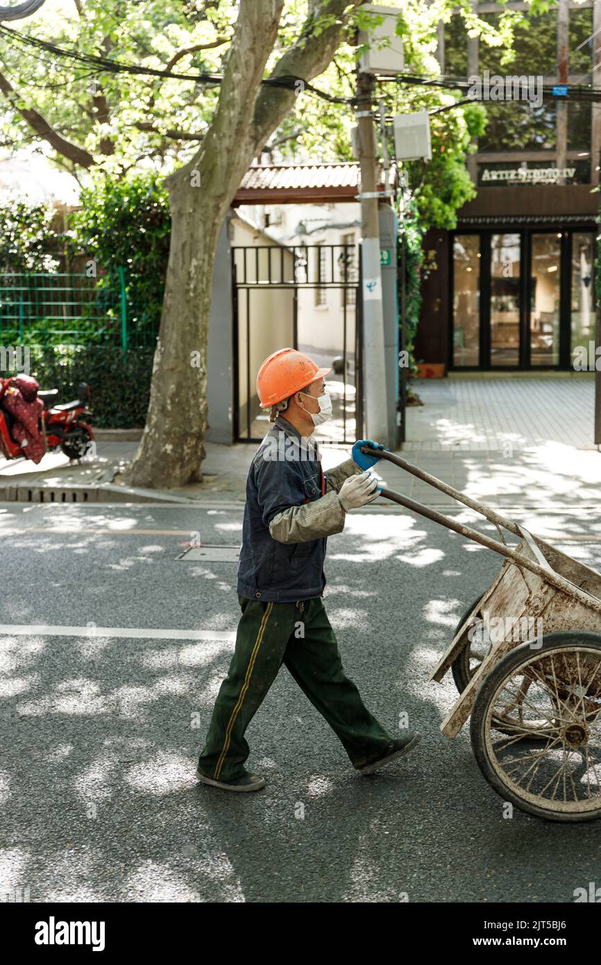 Construction worker pushing wheelbarrow hi-res stock photography and ...