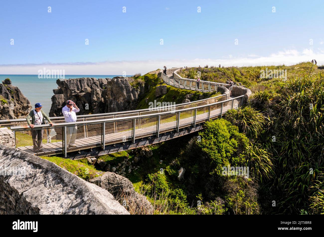 Visitors cross a wooden bridge to see the high lime-stoned pancake ...