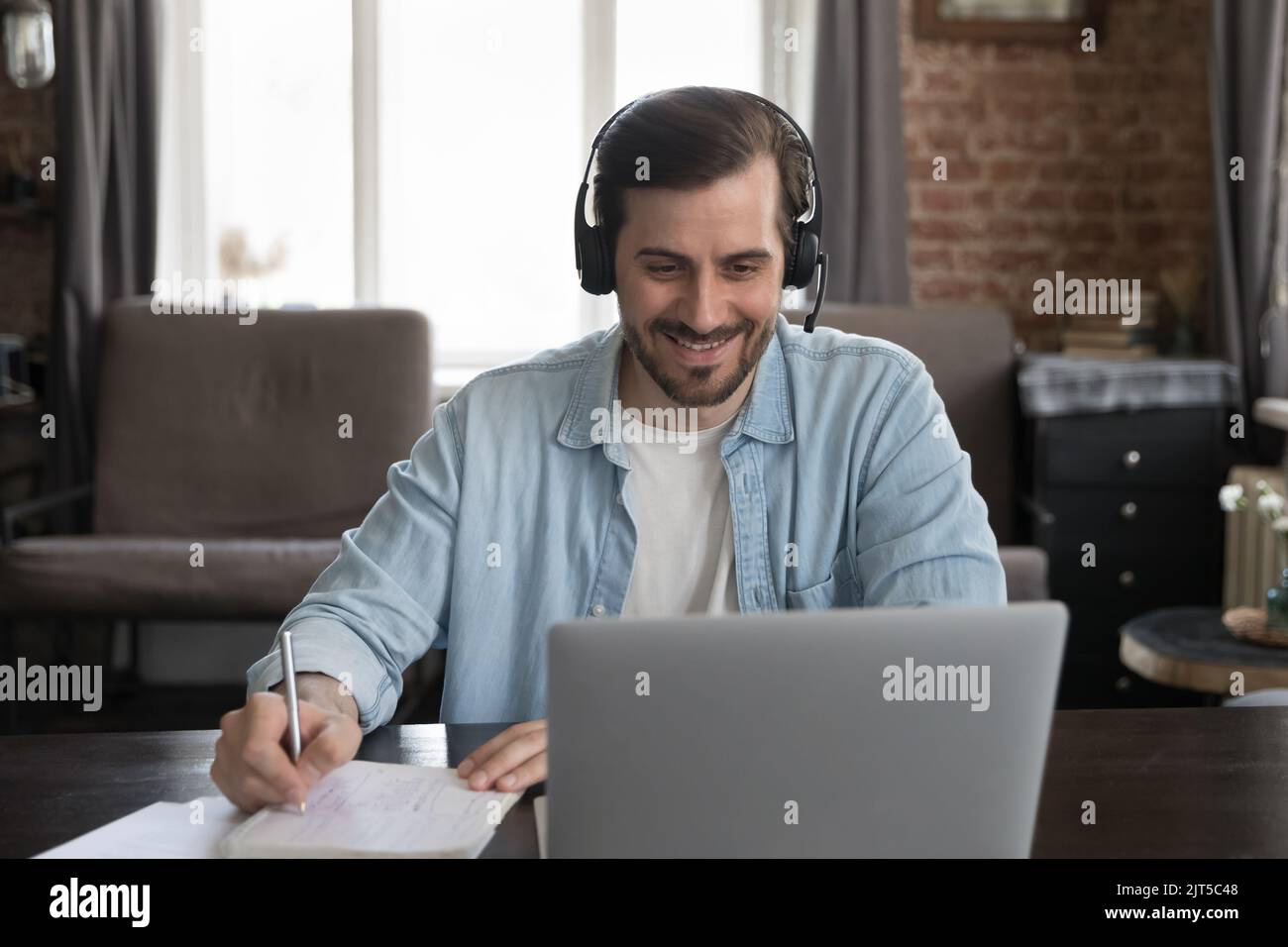 Happy millennial laptop user man wearing wireless headset Stock Photo ...