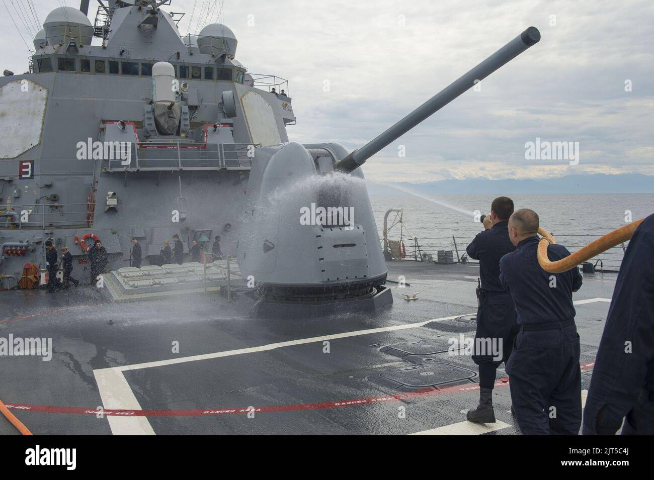 U.S. Sailors conduct a fresh-water washdown aboard the guided-missile ...