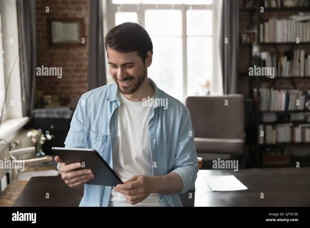 Happy millennial tablet user man reading text on gadget screen Stock ...