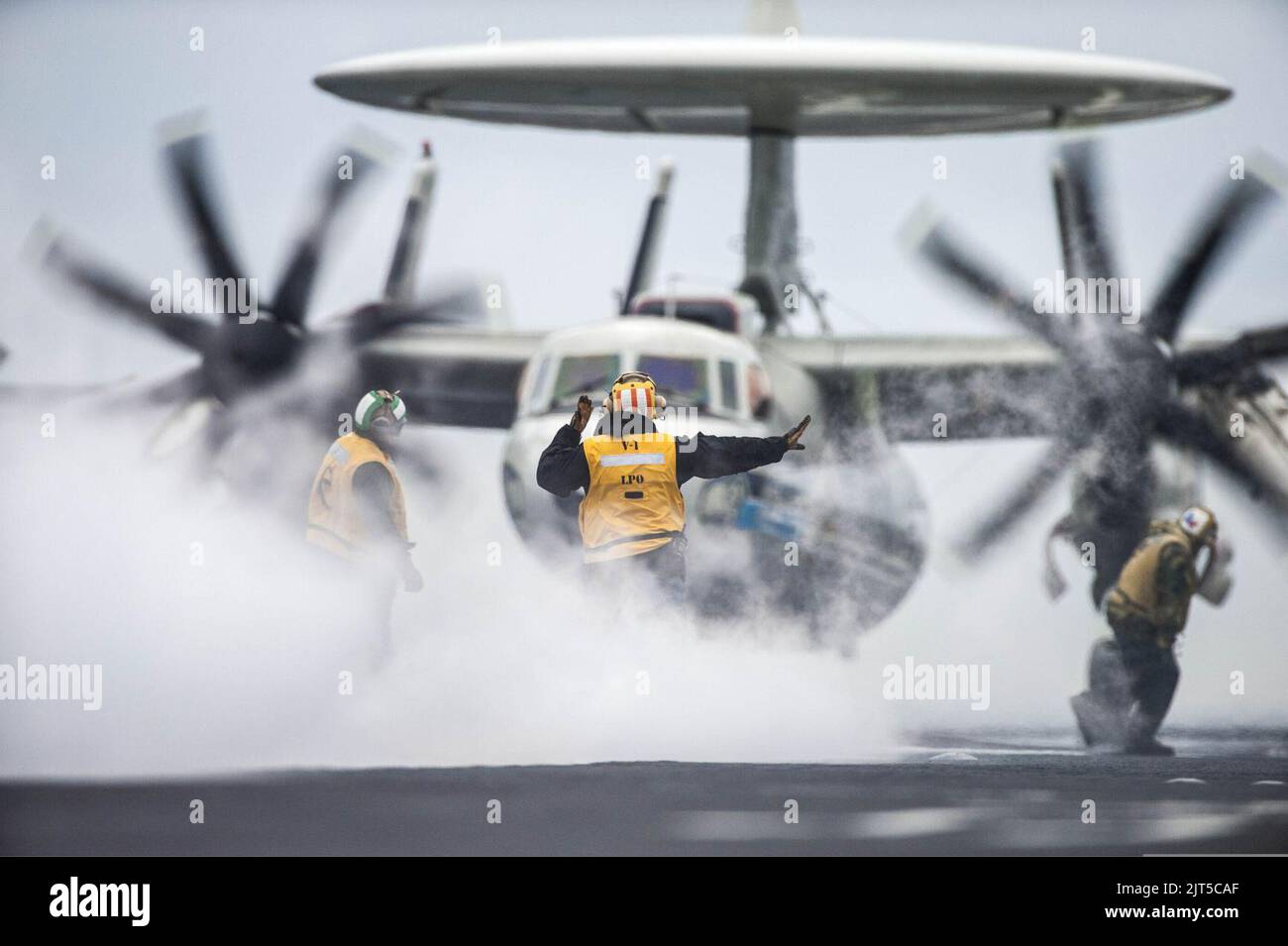 U.S. Sailors guide an E-2C Hawkeye aircraft assigned to Carrier ...