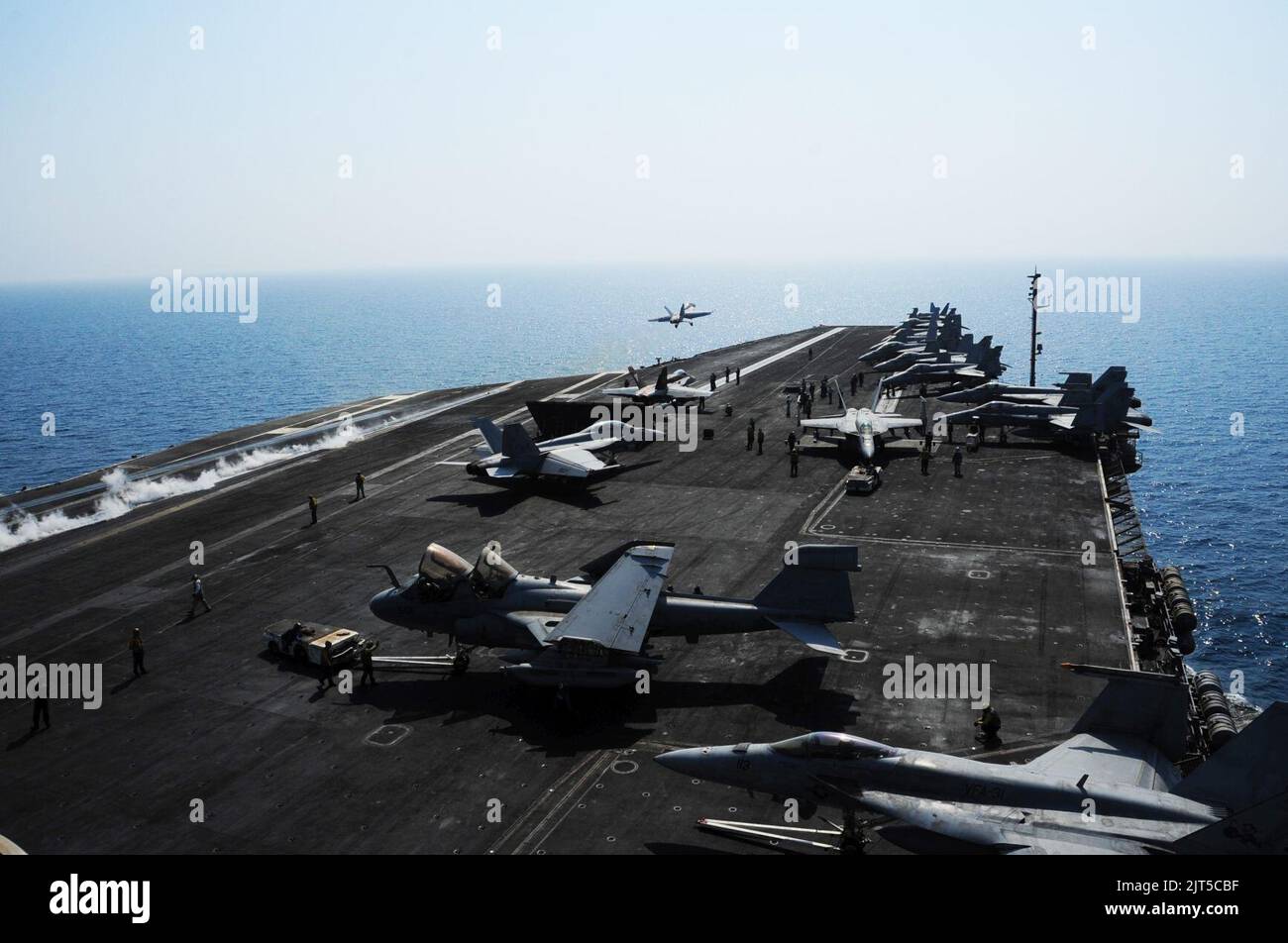 U.S. Sailors move an EA-6B Prowler aircraft, second from front ...