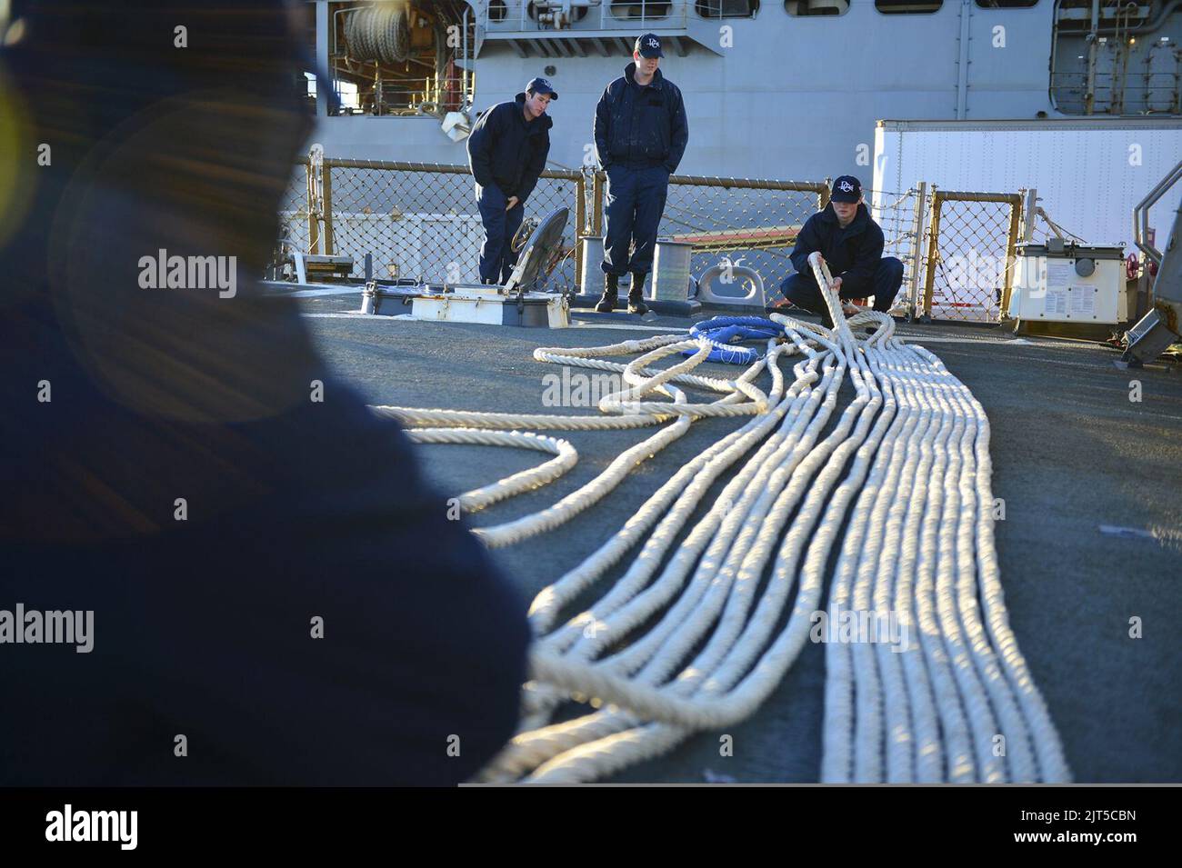 U.S. Sailors organize mooring lines aboard the guided missile destroyer ...
