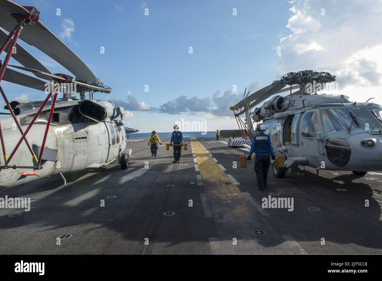 U.S. Sailors move two MH-60S Seahawk helicopters assigned to Helicopter ...