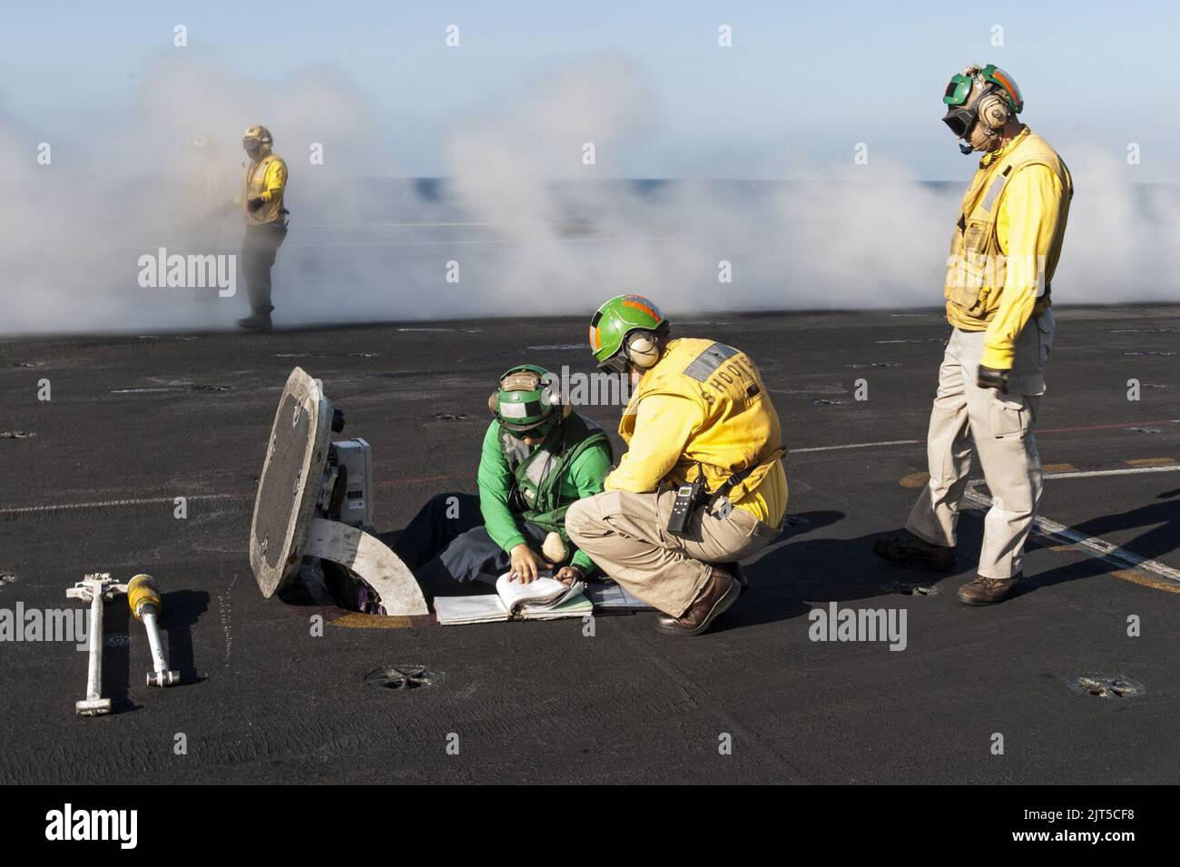 U.S. Sailors prepare a catapult to launch an aircraft on the flight ...