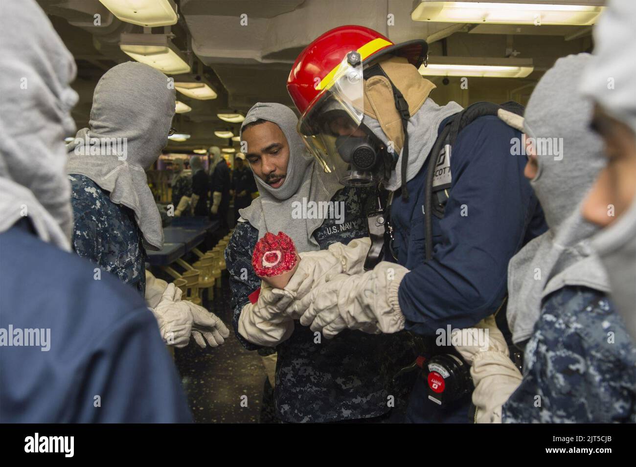 U.S. Sailors simulate an injury during a general quarters drill aboard ...