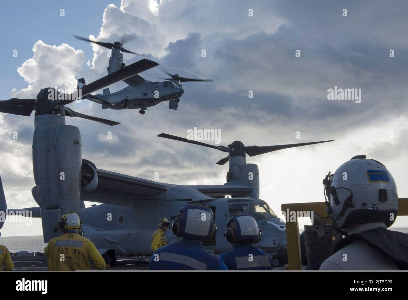 U.S. Sailors watch as a Marine Corps MV-22B Osprey tiltrotor aircraft ...