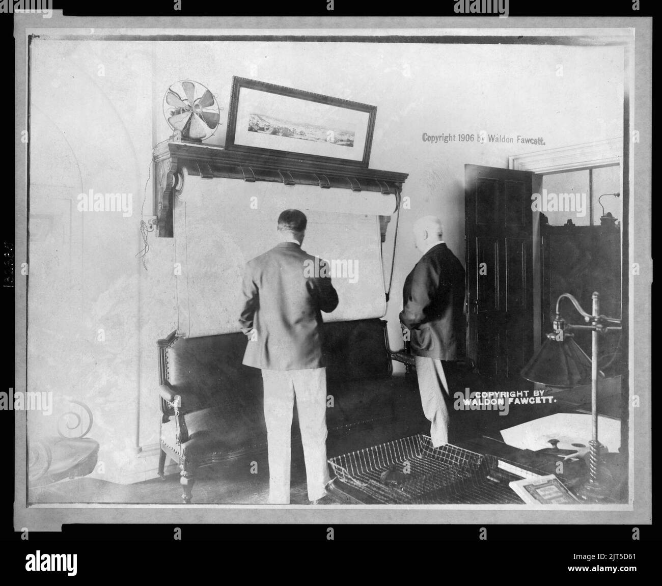 U.S. Secret Service Chief John E. Wilkie examining map in his office ...