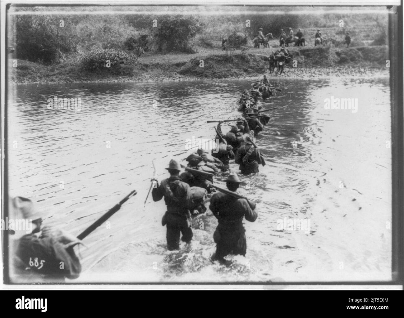 U.S. soldiers fording river during Philippine Insurrection. 1899 Stock ...