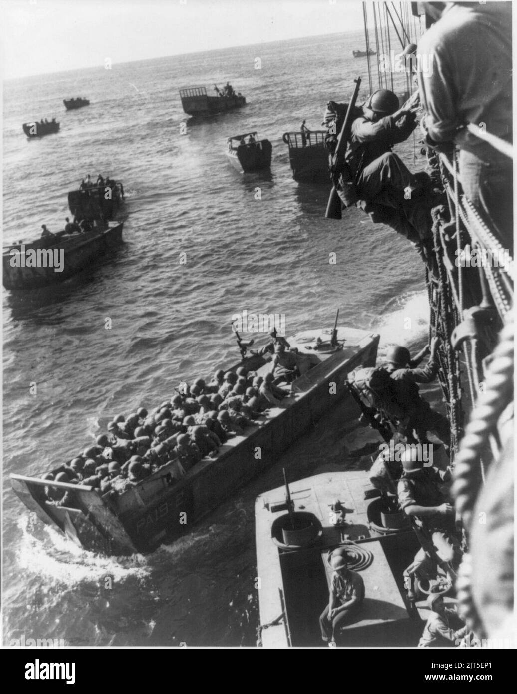 U.S. troops going over the side of a combat transport to enter the ...