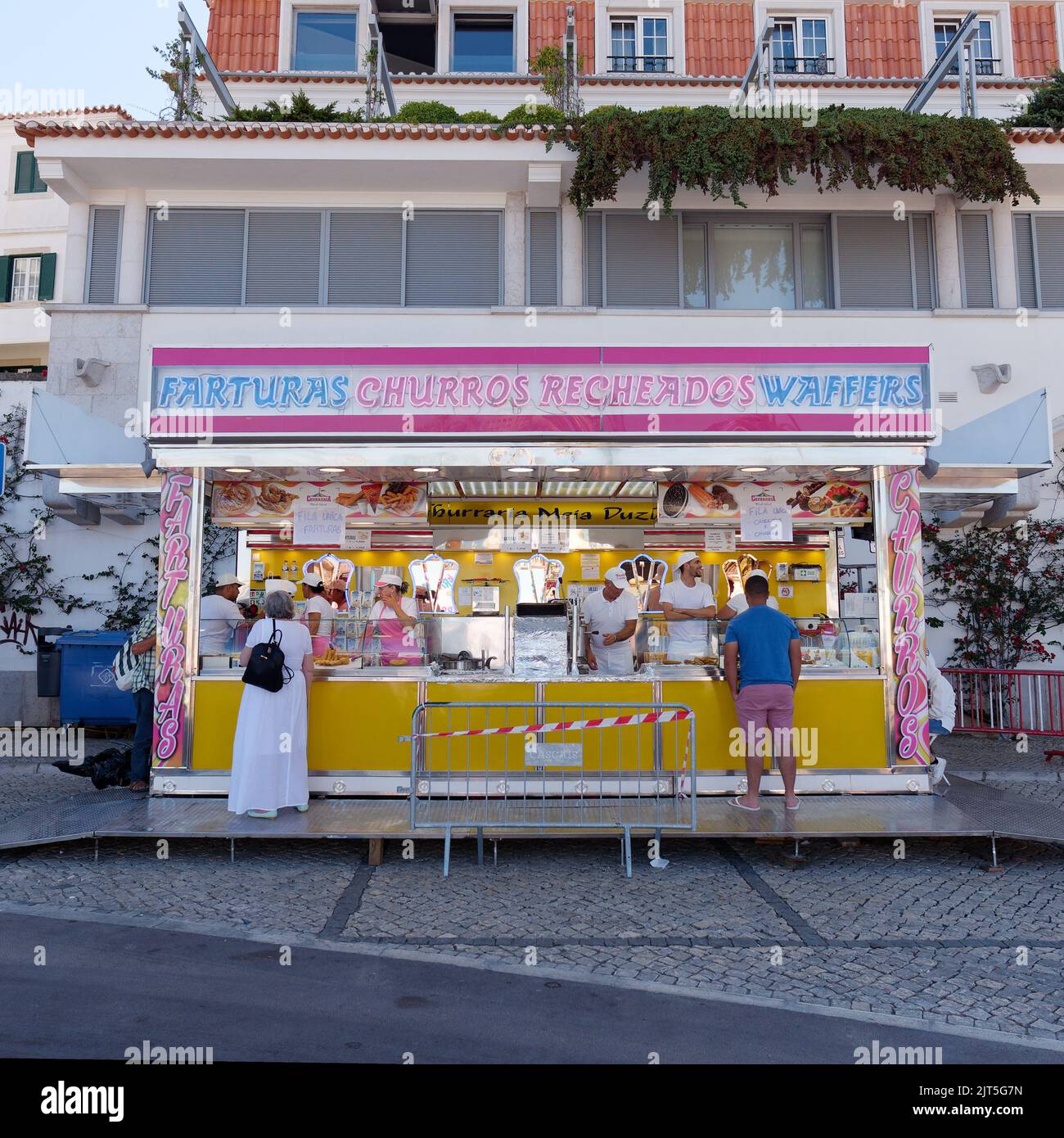 Churros outdoor vendor stall in yellow and pink in the town of Cascais ...
