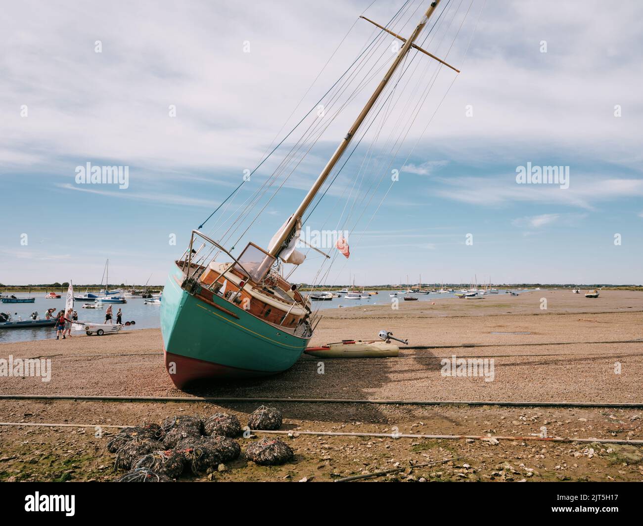A yacht on the hard in the low tide summer landscape and boats at West ...