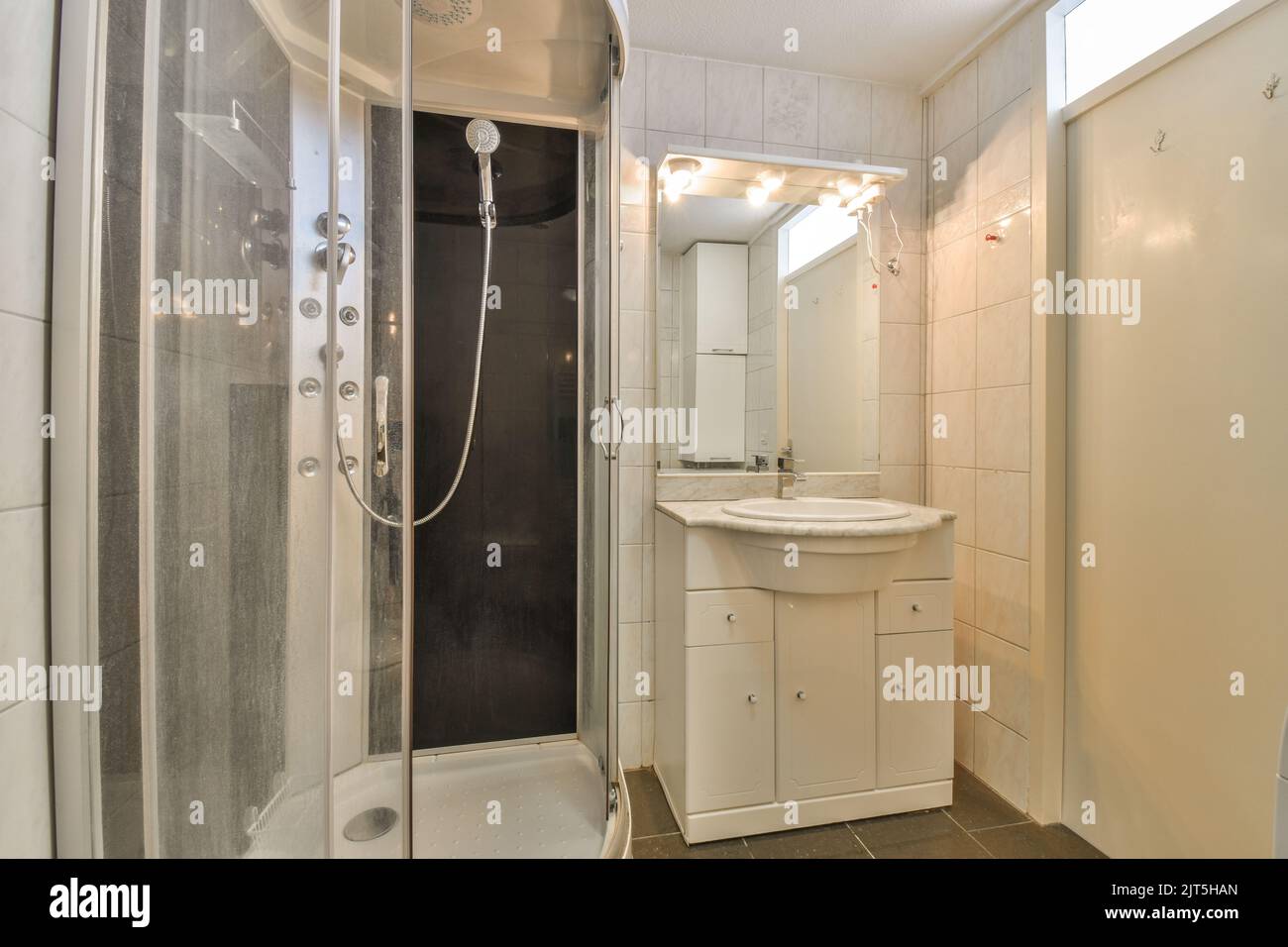 Sinks with mirrors and shower box with glass door in modern bathroom ...