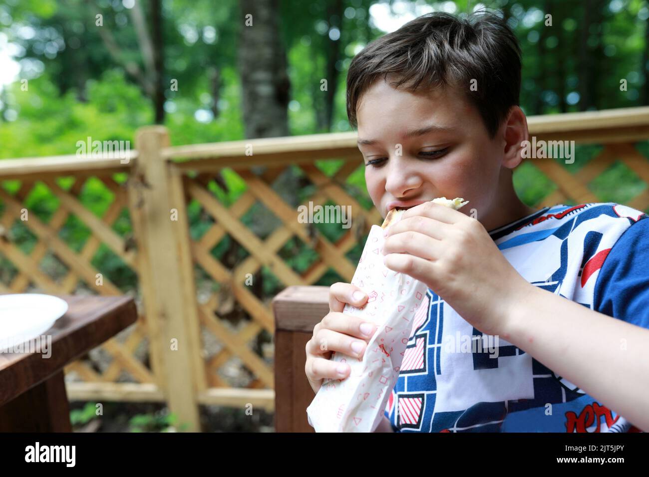 Hungry child eating shawarma on restaurant terrace Stock Photo - Alamy