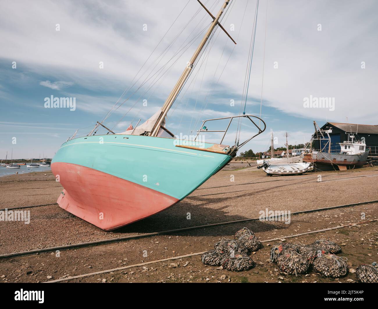 A yacht on the hard in the low tide summer landscape and boats at West ...