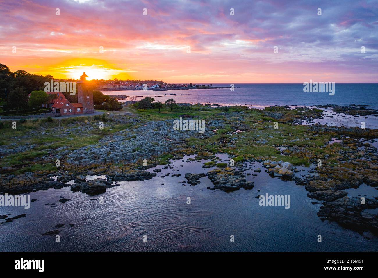 aerial view of svaneke lighthouse at coast during sunset on bornholm ...