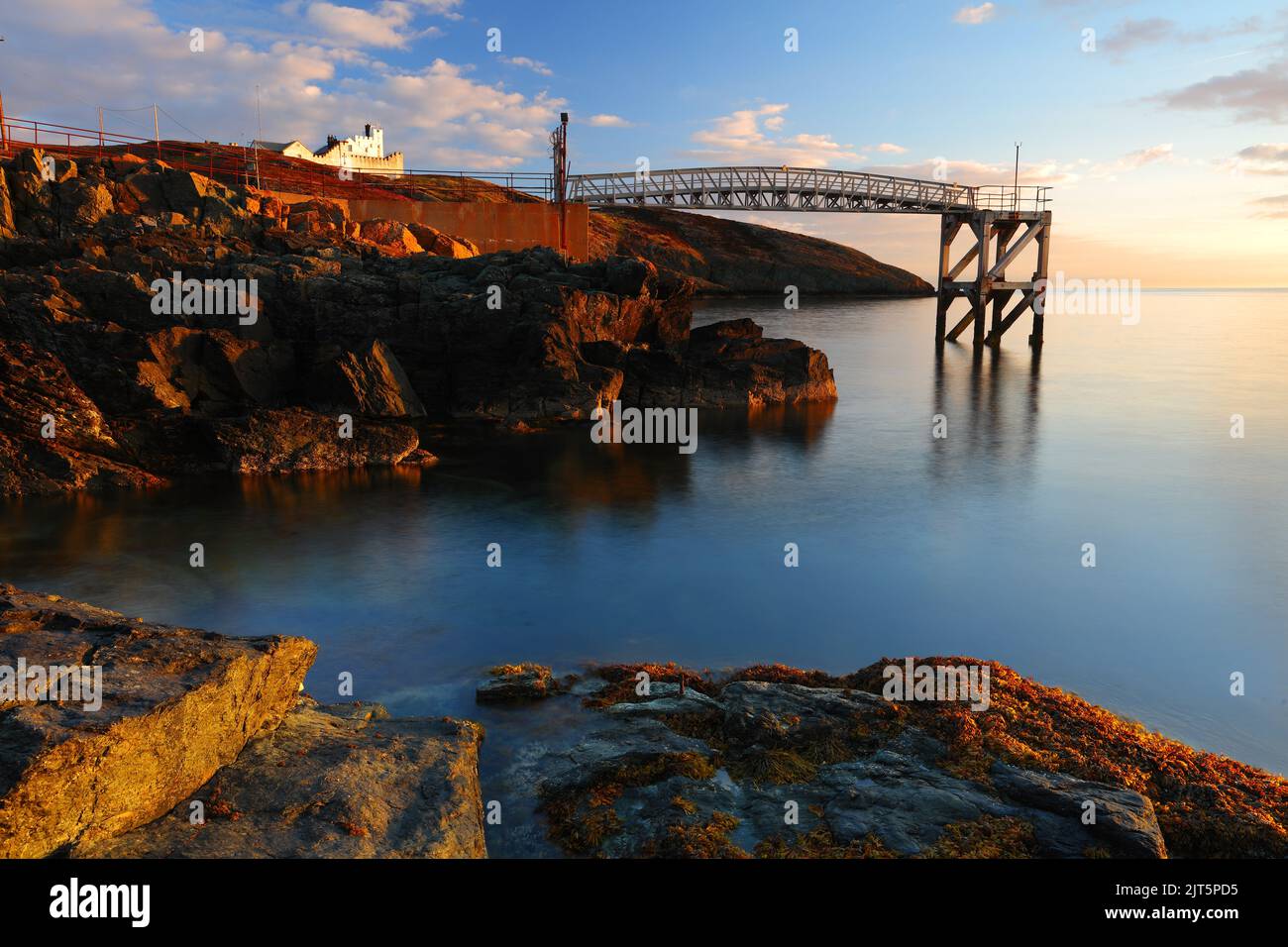 Point Lynas Lighthouse at first light with calm blue sea. Anglesey ...