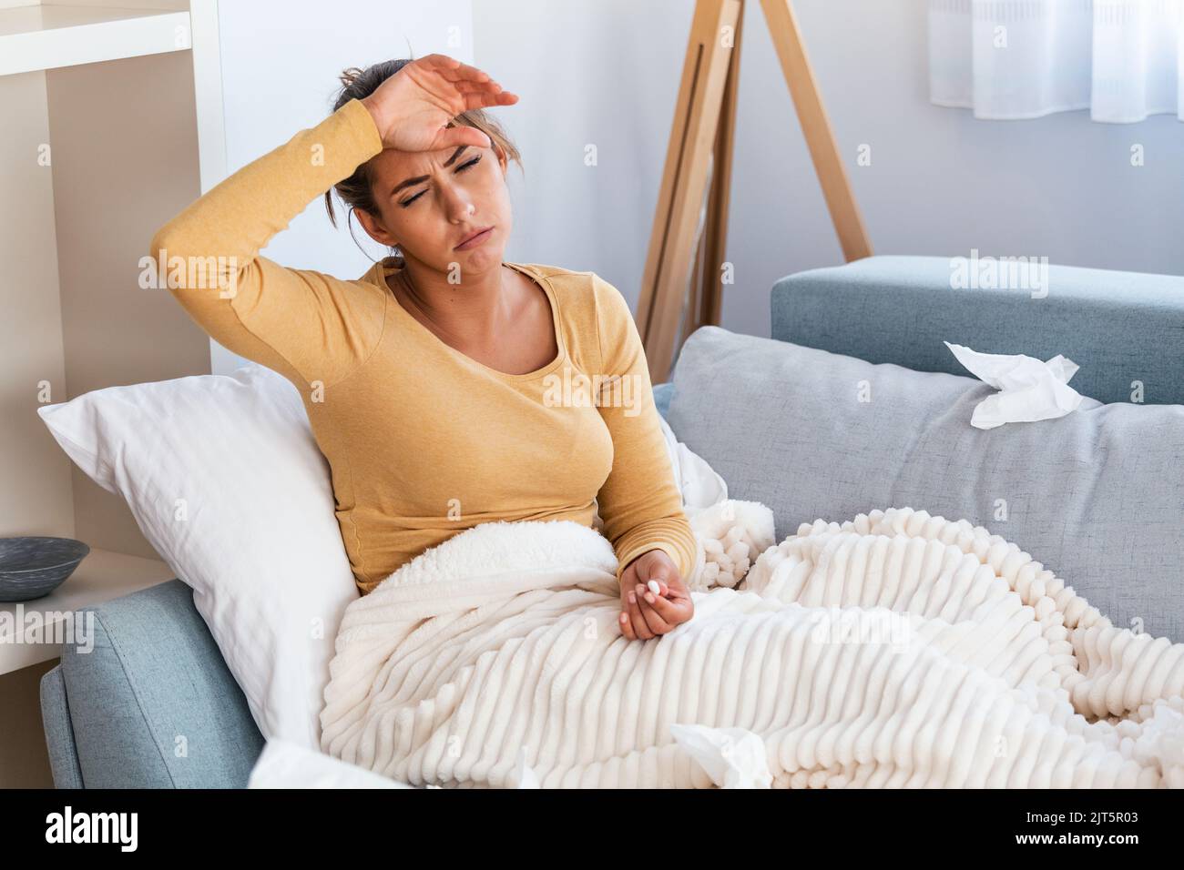 Sick day at home. Young woman has runny and common cold. Cough. Closeup ...