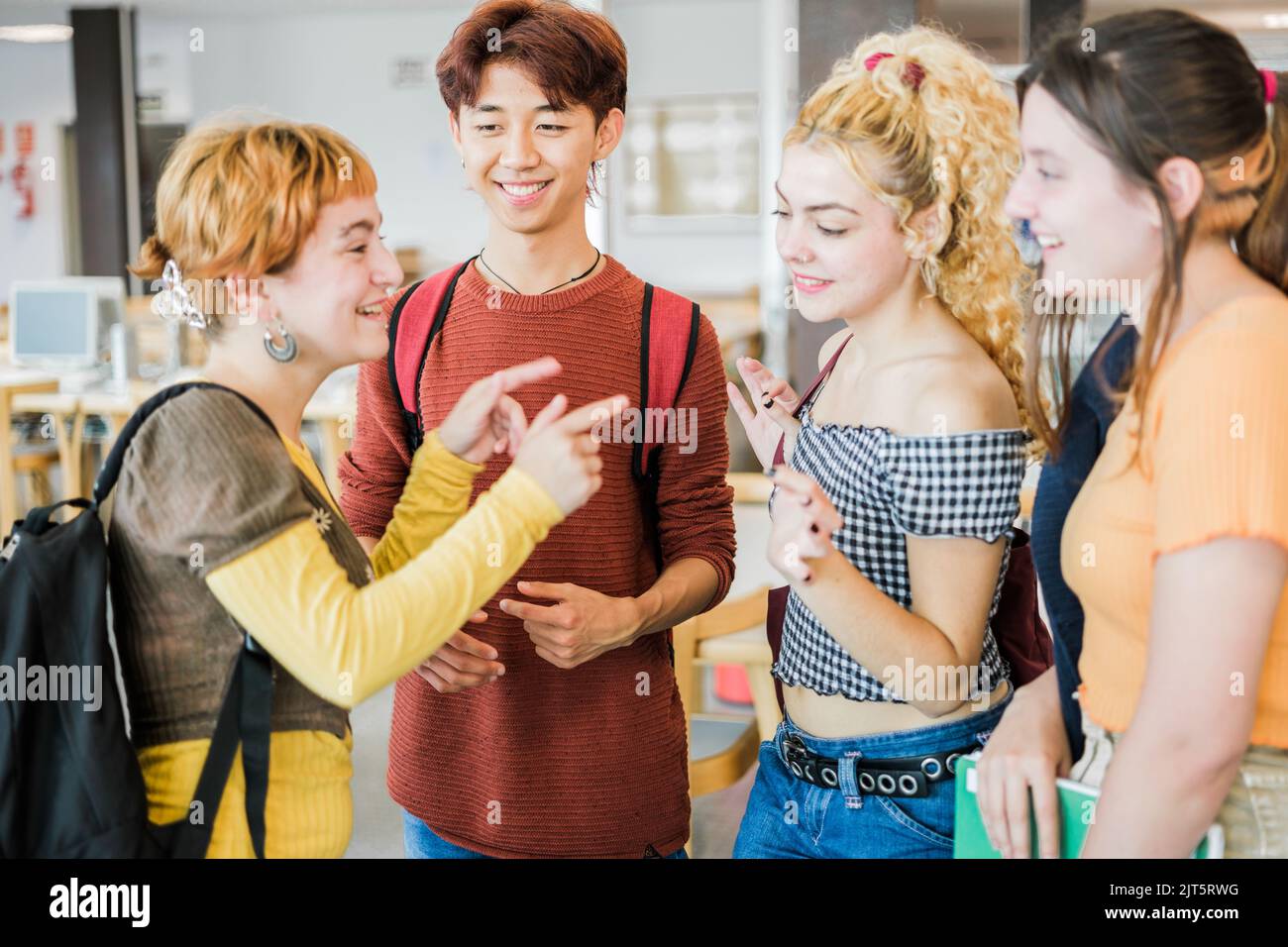 Group of classmates exchanging opinions inside the university library ...