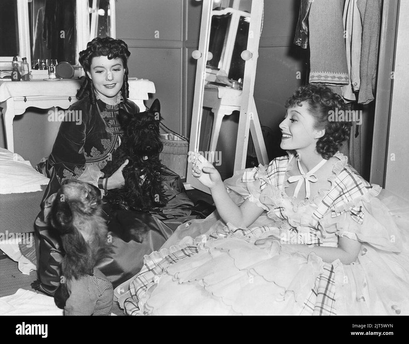 Актрисы Barbara O'Neil и Luise Rainer в гримерке с собакой мисс O'Neil ...