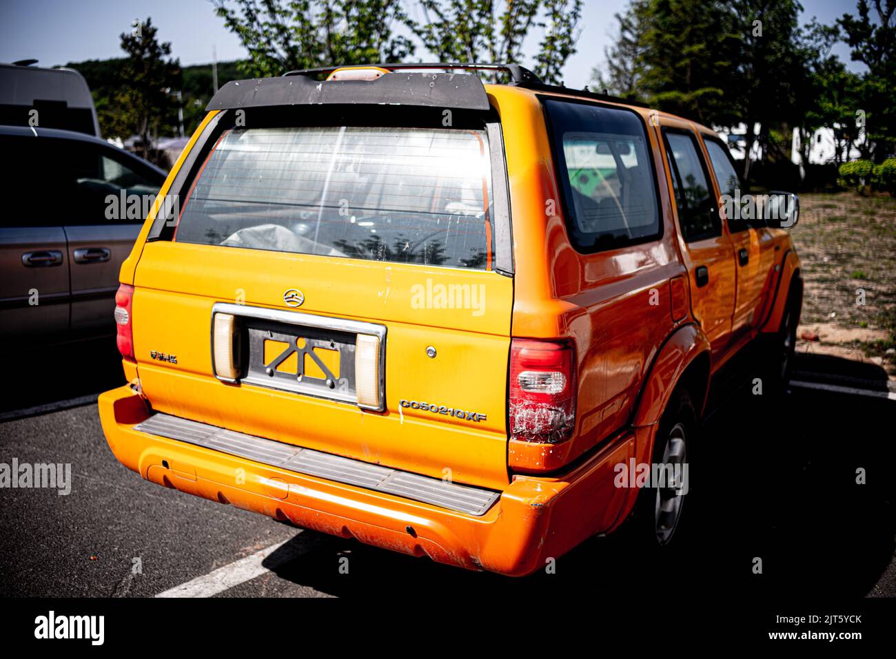 A back view shot of a yellow Great Wall safe car parking on the street ...