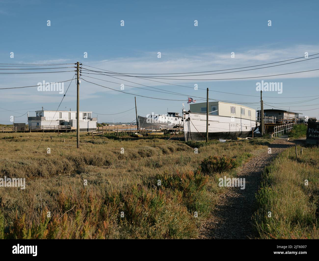 The summer houseboat and low tide salt marsh landscape of West Mersea ...