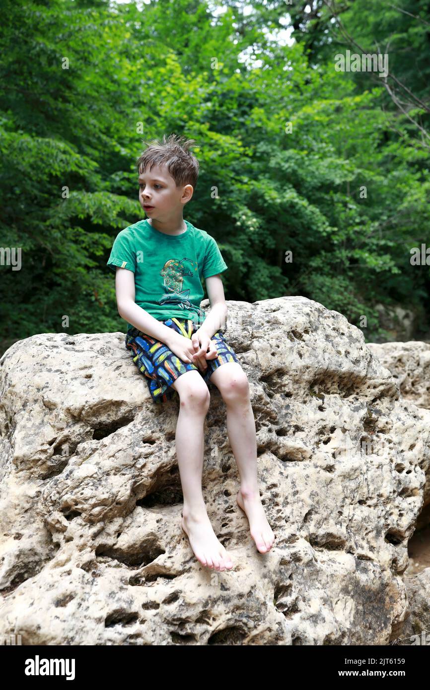 Boy sitting on stone in Belaya River Valley, Adygea Stock Photo - Alamy