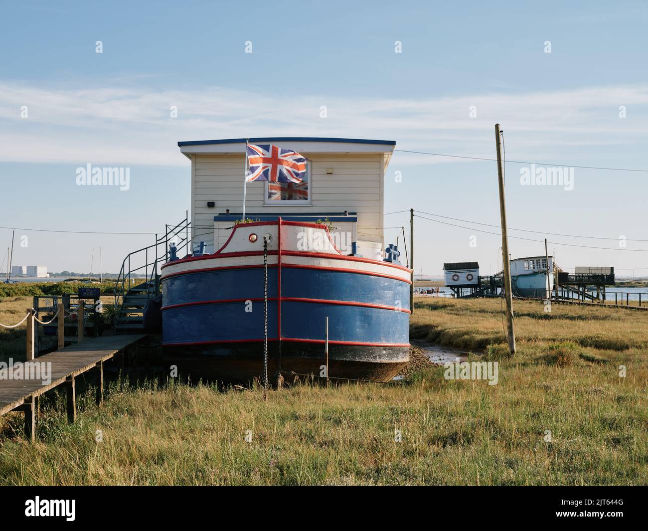 The summer houseboat and low tide salt marsh landscape of West Mersea ...