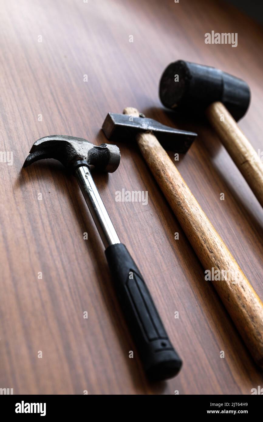 A vertical shot of a claw hammer, a sledgehammer, and a rubber mallet ...