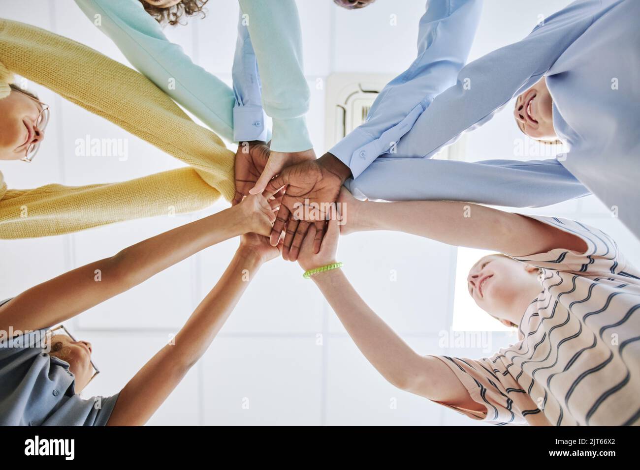 Low angle view diverse group of children stacking hands and huddling in ...