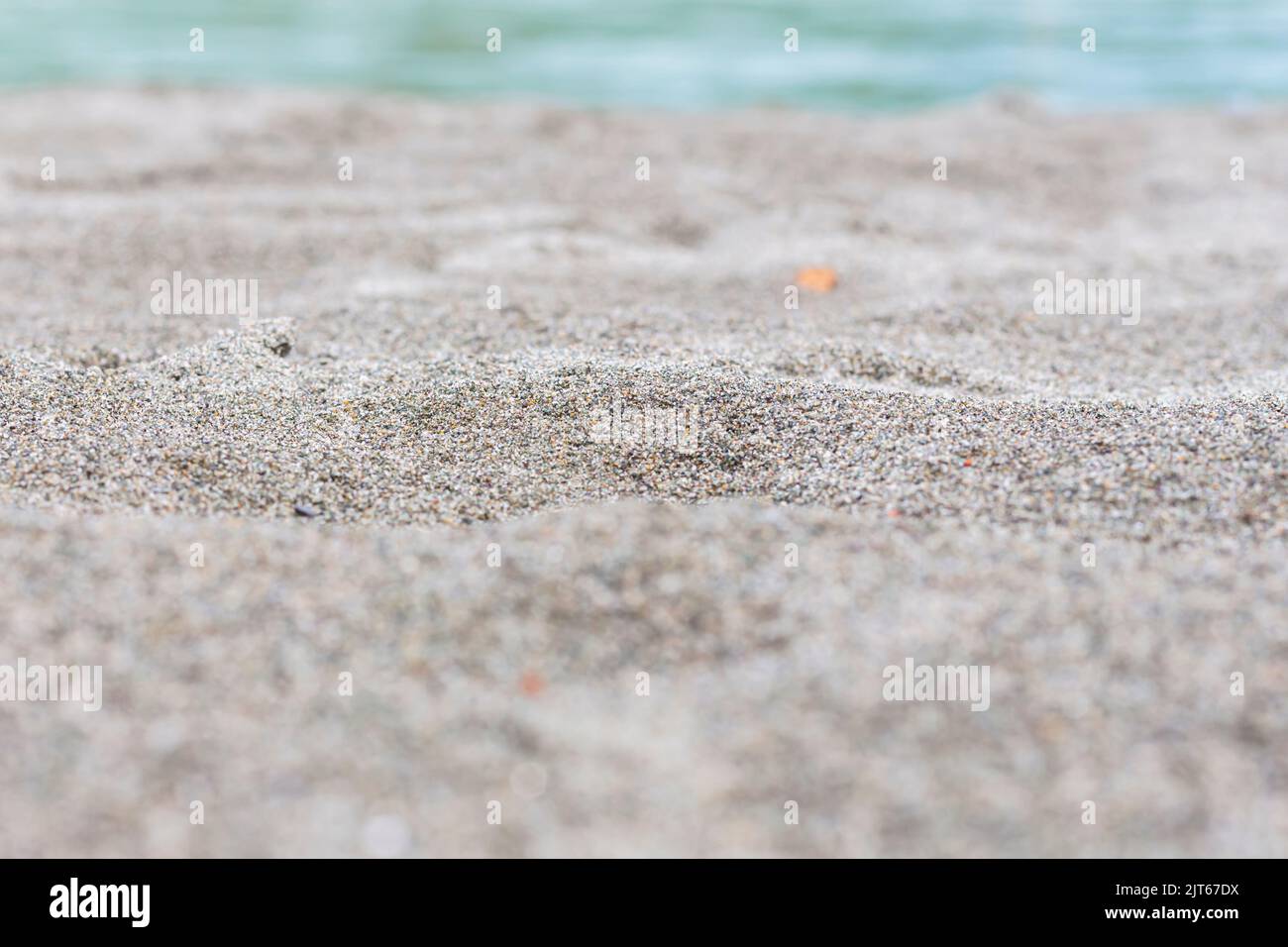 Beach sand blue sea water summer background with shallow depth of field ...