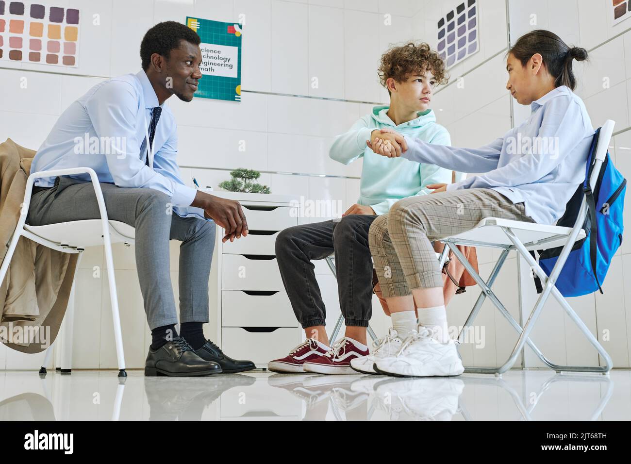 Portrait of two boys shaking hands in therapist office with school ...