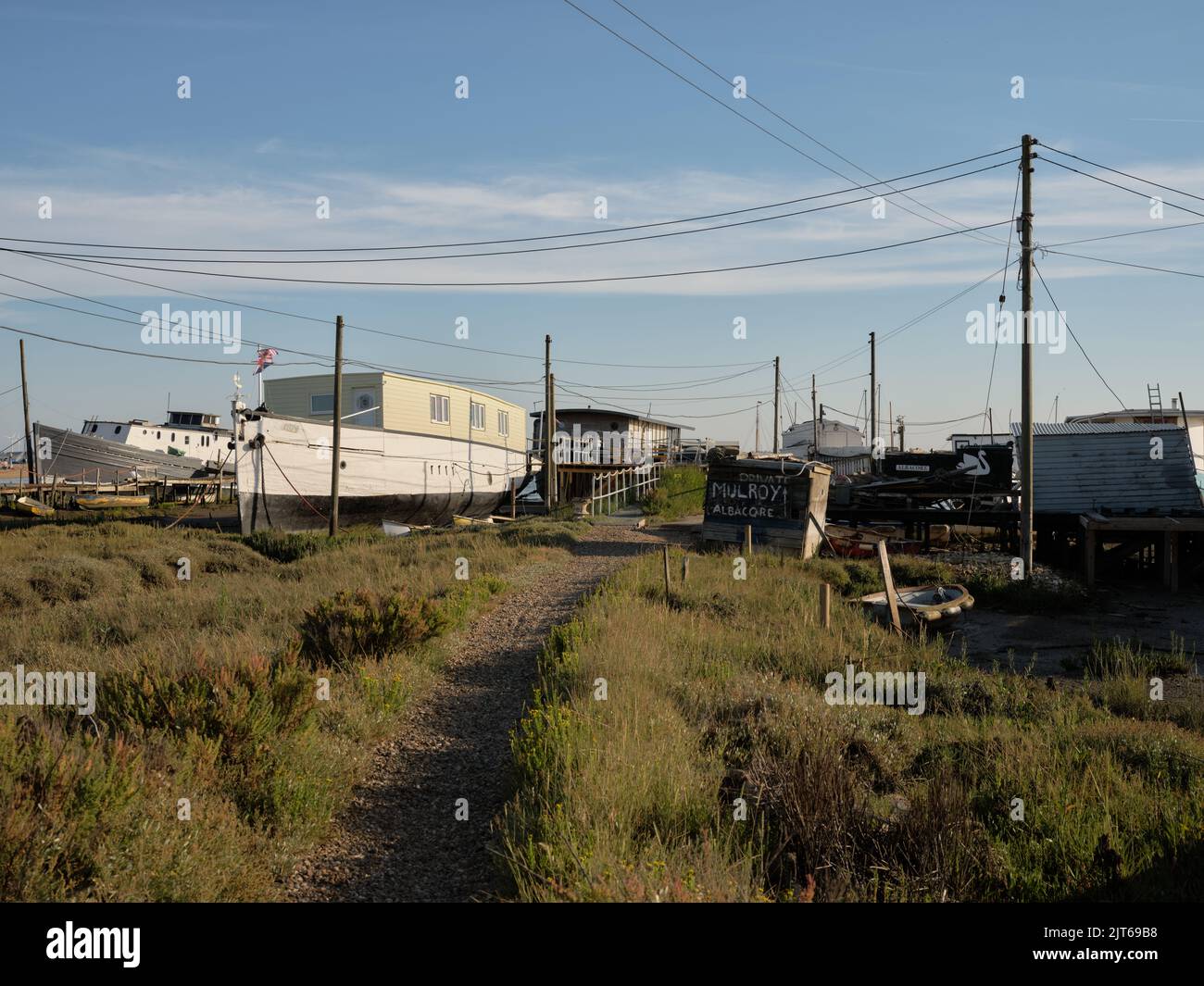 The summer houseboat and low tide salt marsh landscape of West Mersea ...