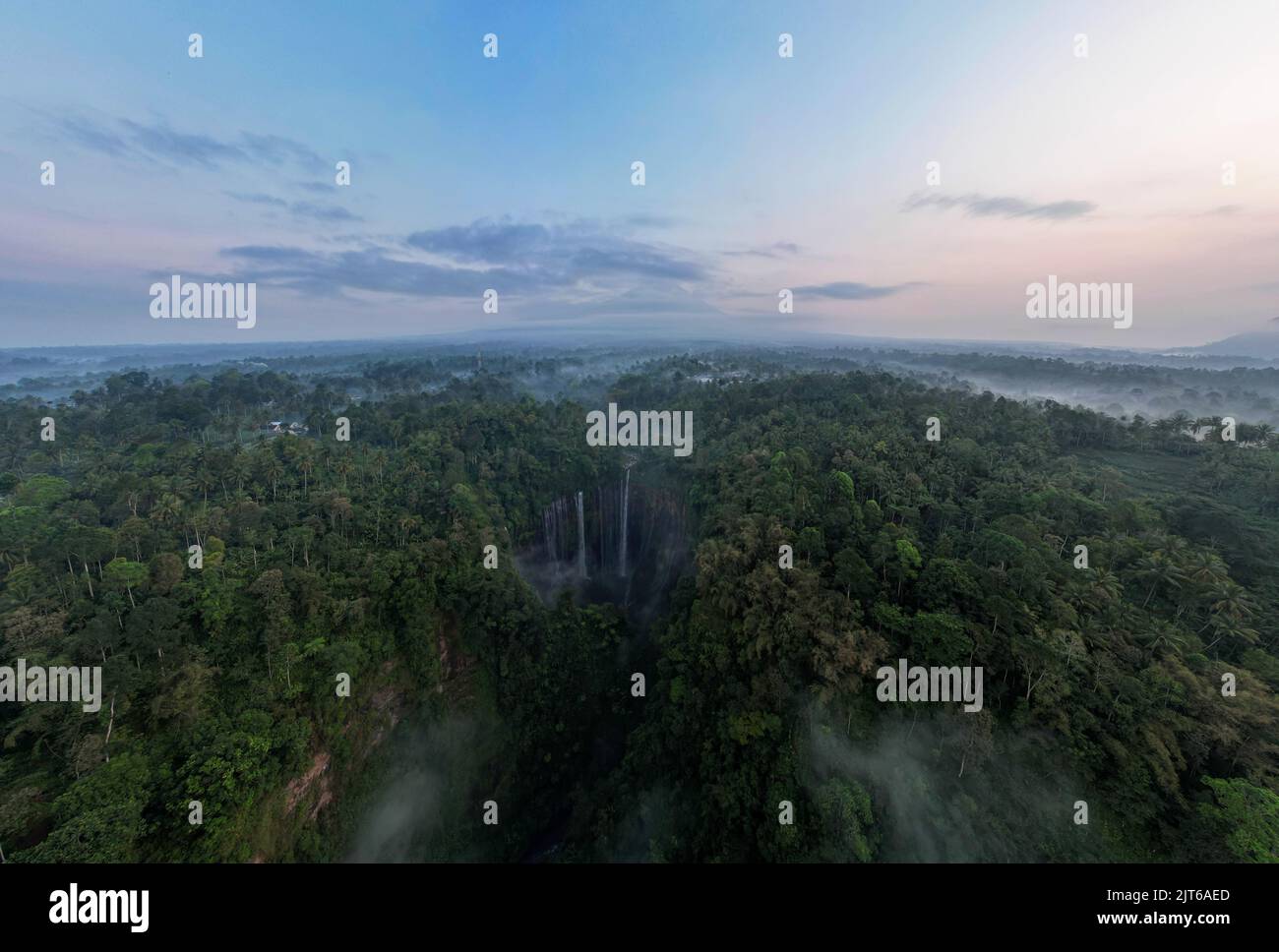 Aerial view of Tumpak Sewu waterfall and Semeru mountain at sunrise ...