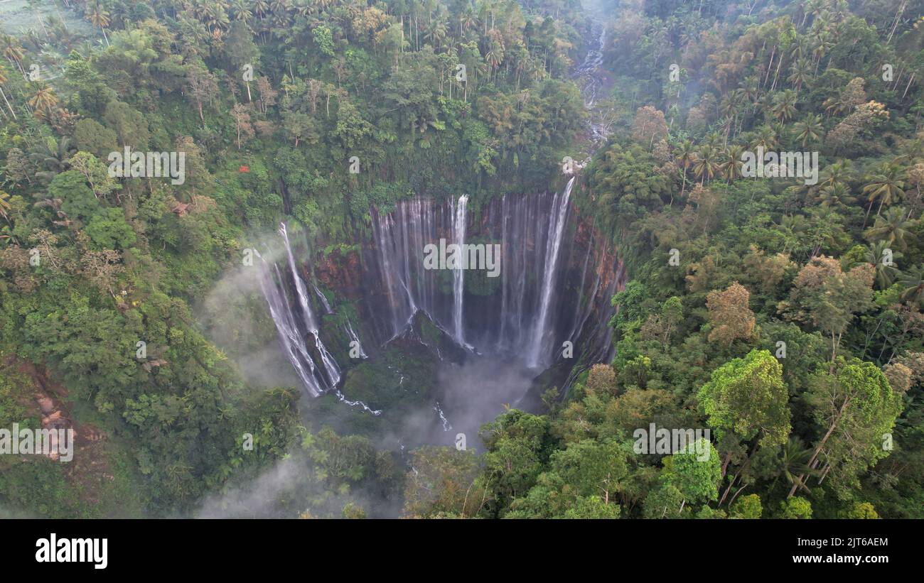 Aerial view of Tumpak Sewu waterfall and Semeru mountain at sunrise ...