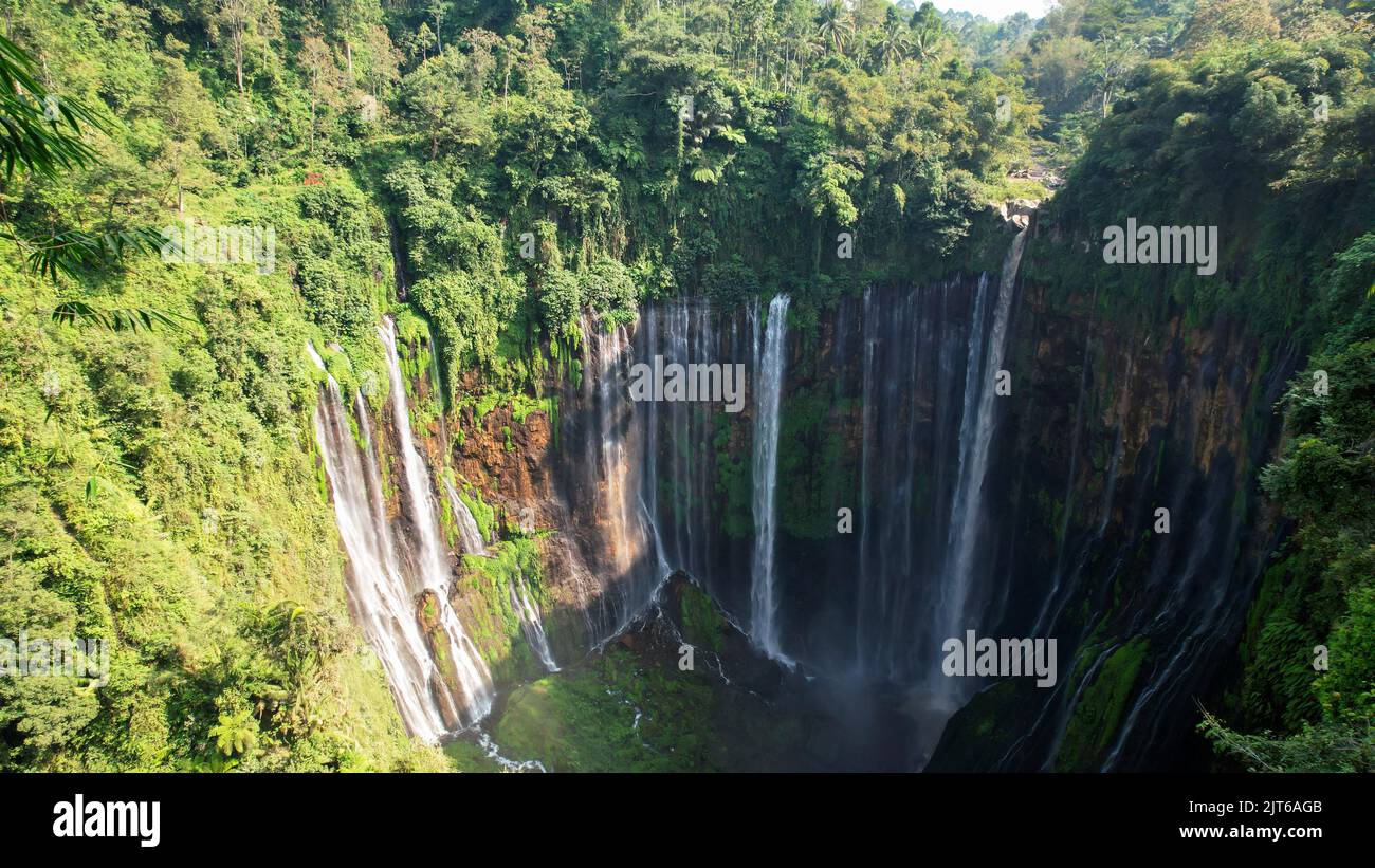 Aerial view of Tumpak Sewu waterfall and Semeru mountain at sunrise ...