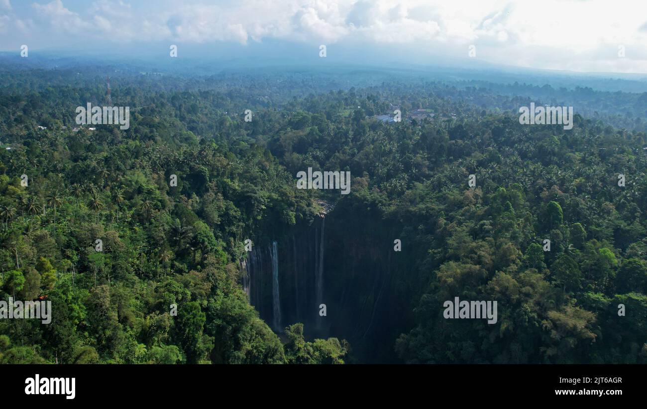 Aerial view of Tumpak Sewu waterfall and Semeru mountain at sunrise ...